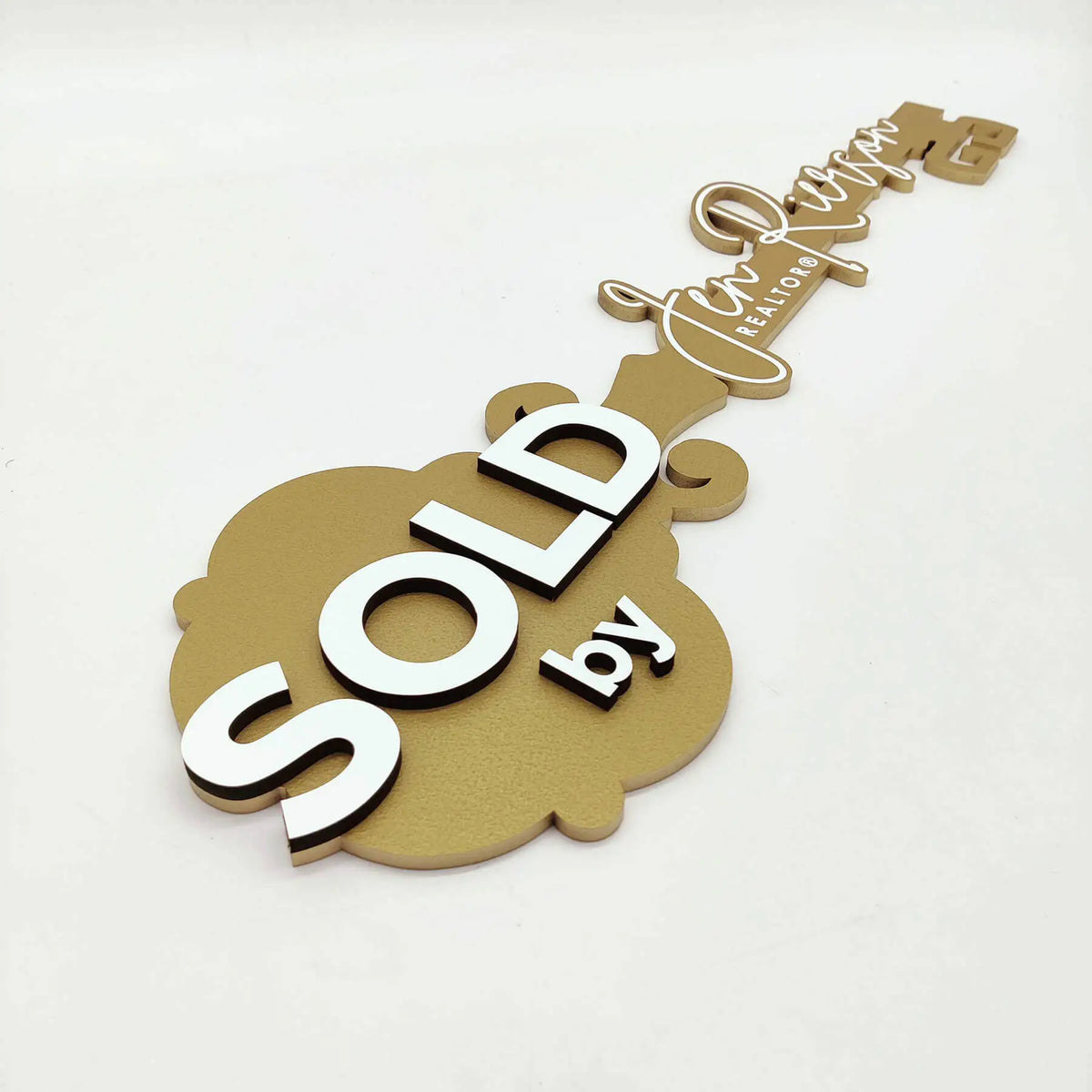 Gold Key-Shaped Sign "Sold By" White Text – Real Estate Store